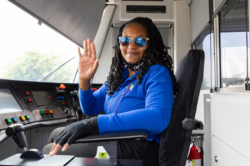 View of light rail operator inside a train cab