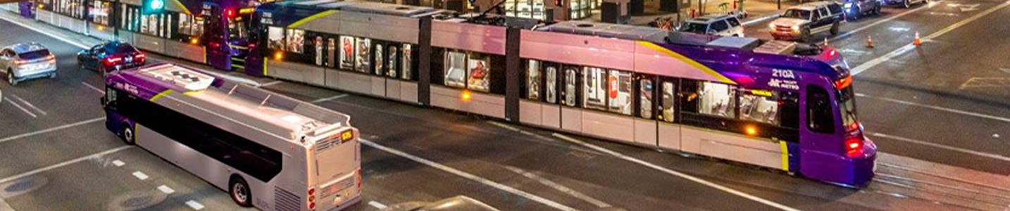 A light rail train and a bus pass each other in downtown Phoenix