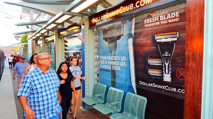 A man looks at light rail station advertising