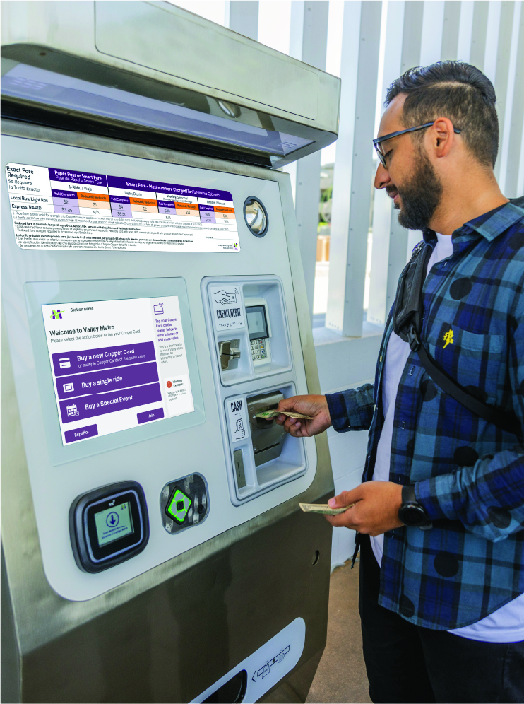 A man making a cash payment at a fare machine