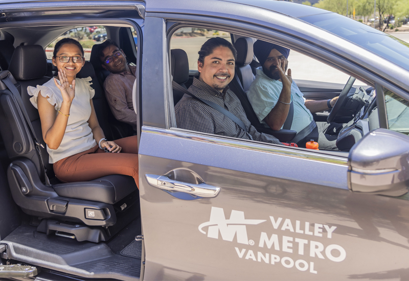 Four smiling people in a Valley Metro vanpool vehicle